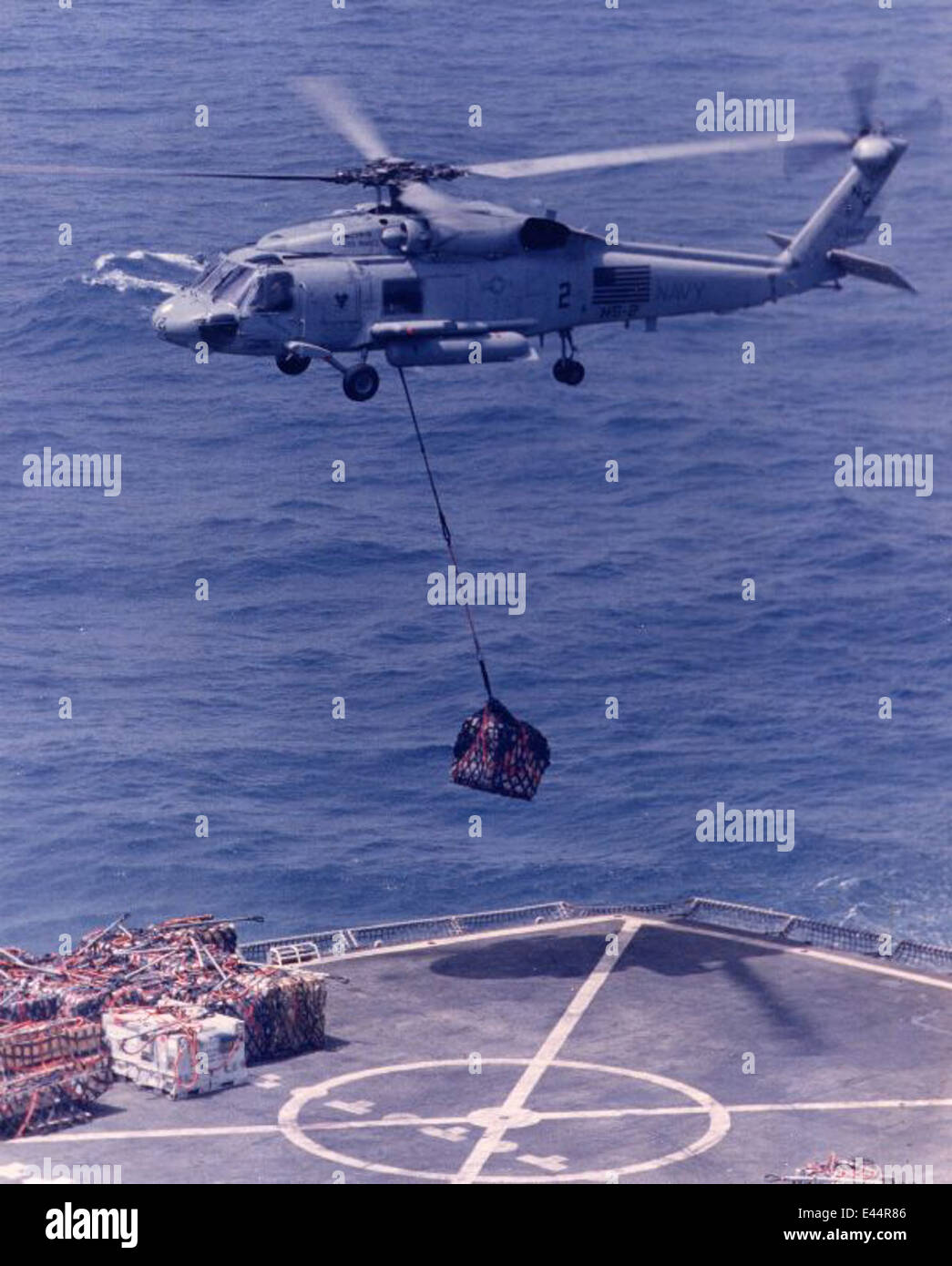 A photograph of an HH-60 helicopter conducting Vertical Replenishment ...
