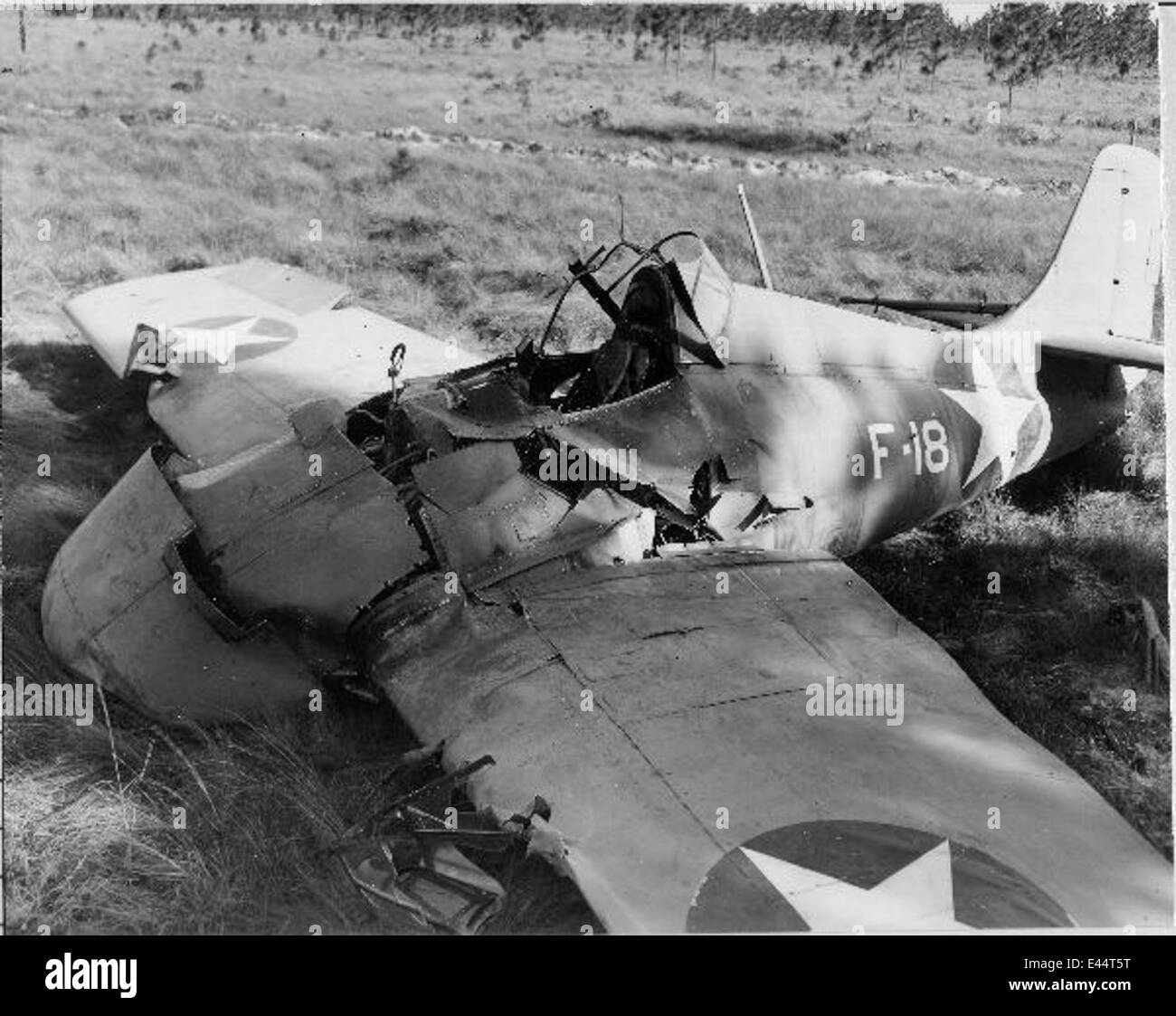 This photograph depicts the aftermath of a crashed F4F-3 Wildcat ...