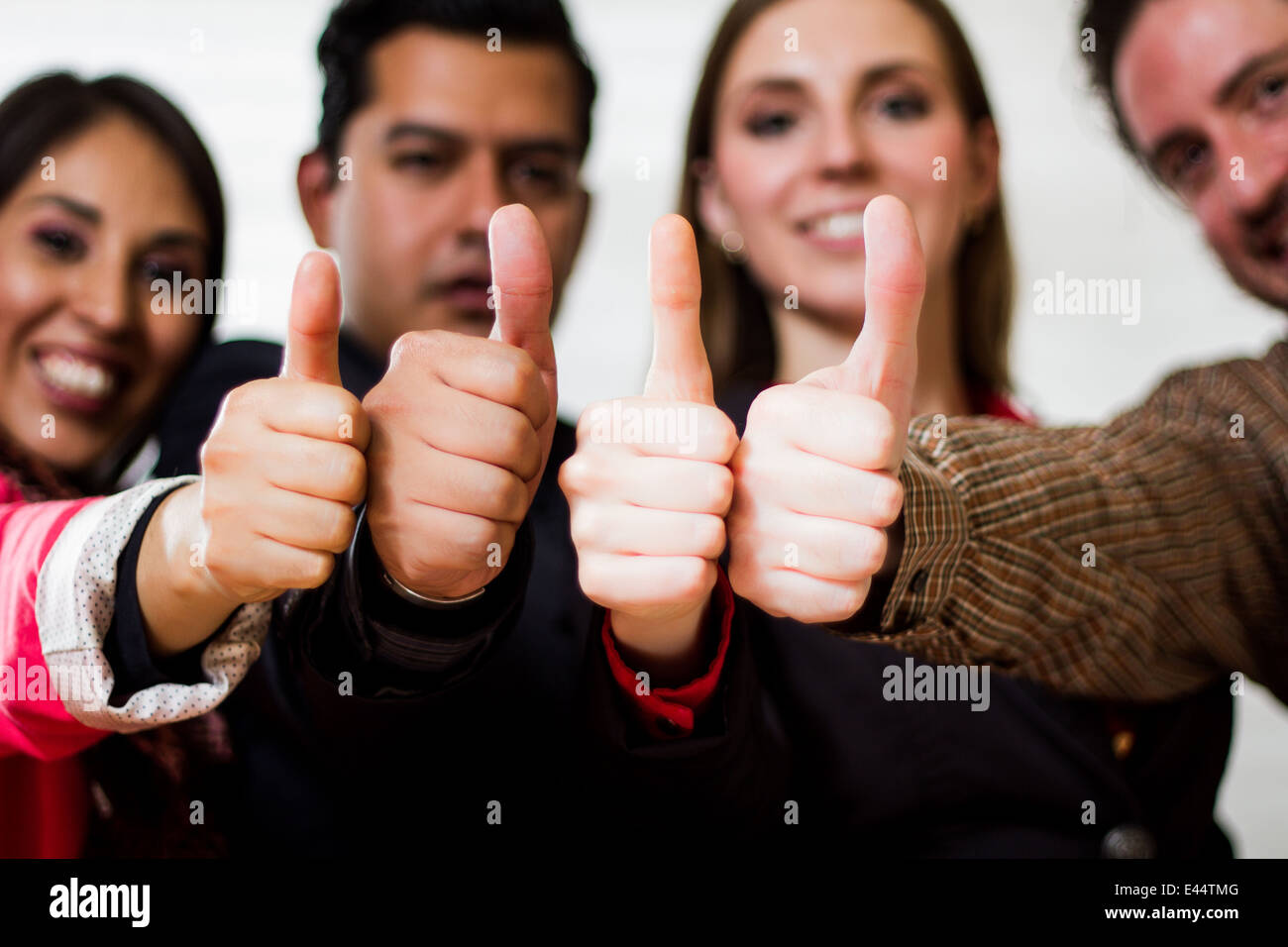 Four people team work, thumbs up Stock Photo - Alamy
