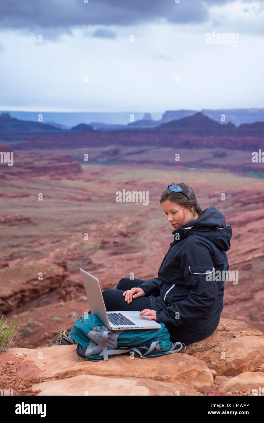 Girl Hiker on top of the mountain with her laptop computer Stock Photo ...