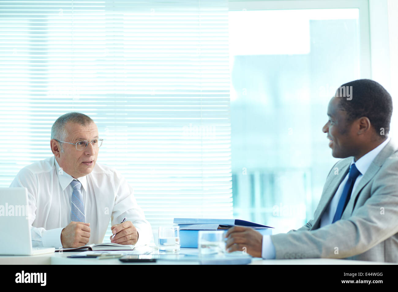 Portrait of senior boss and his employee talking at meeting Stock Photo ...