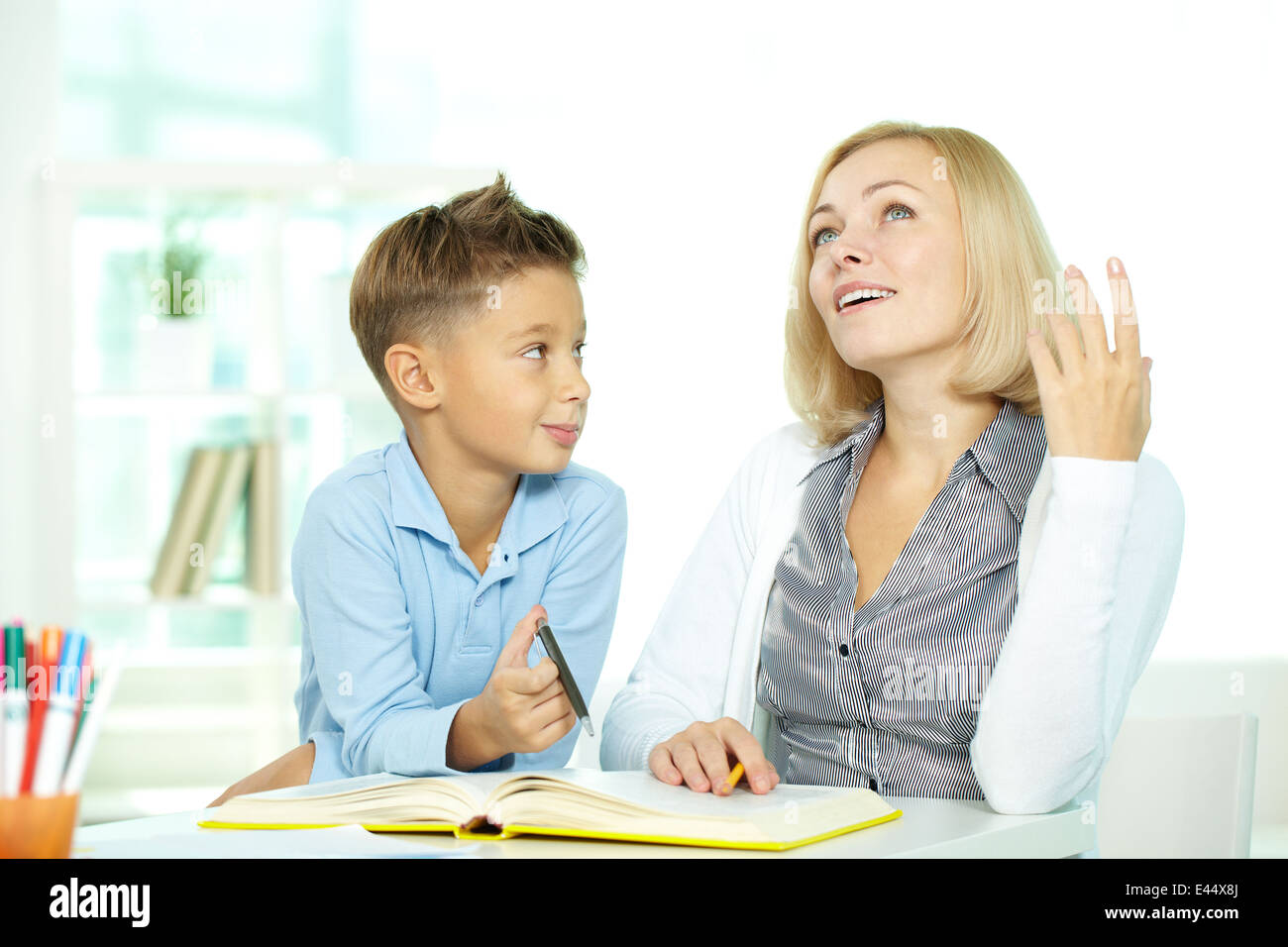Portrait of pretty tutor sharing her idea of plot while discussing book ...