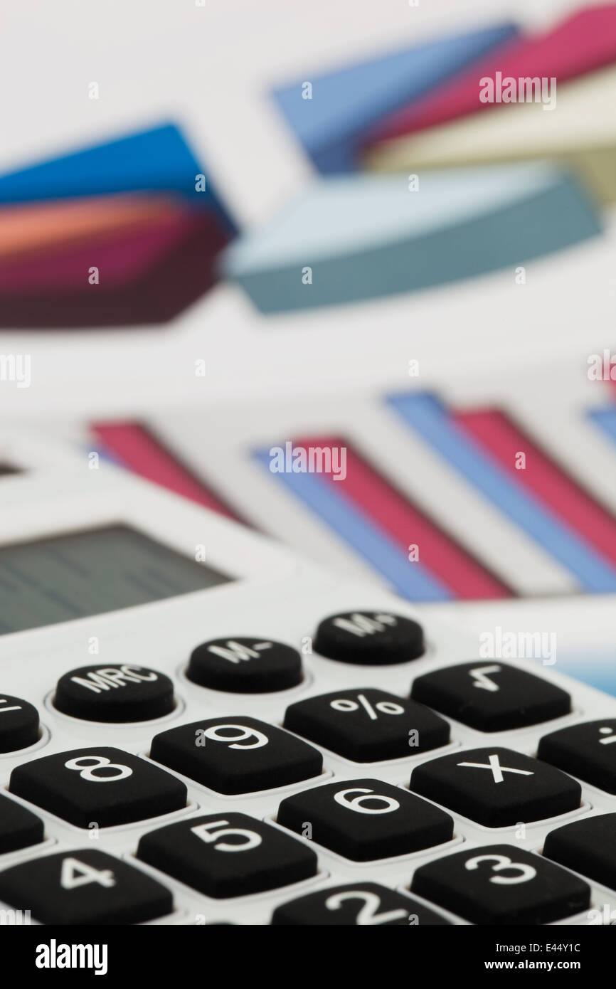A calculator with graphics of a balance sheet. Sales, profit and ...