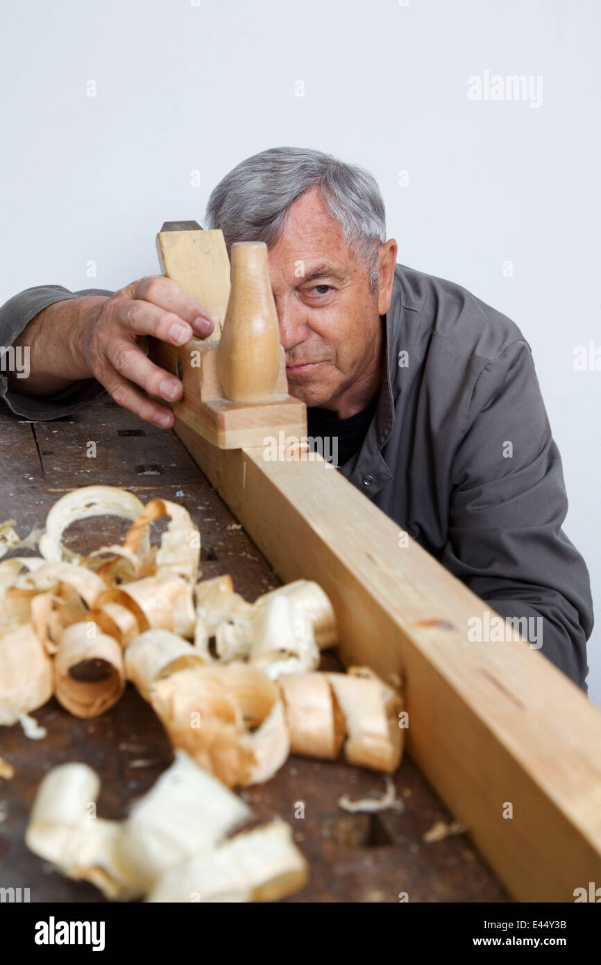 A carpenter with a planer and wood shavings in the workshop Stock Photo ...