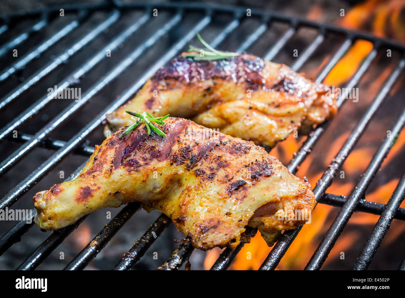 Roasted chicken legs on the grill with fire Stock Photo - Alamy
