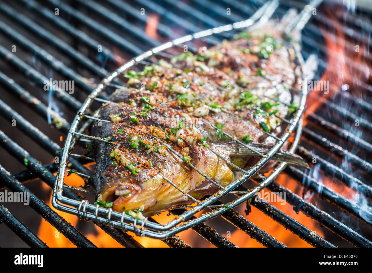 Baked fish on the grill with fire Stock Photo - Alamy