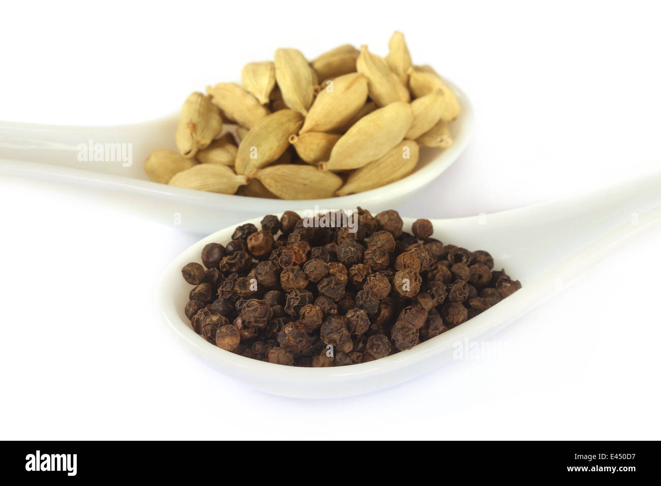 Black peppers with cardamom on white spoon Stock Photo - Alamy