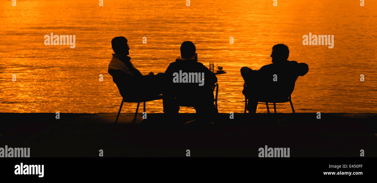 Friends talking by the sea Stock Photo - Alamy