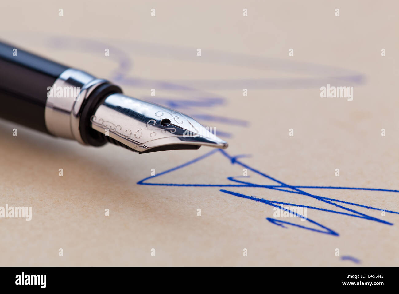 A fountain pen and a signature on yellow paper. Symbolic of closing ...