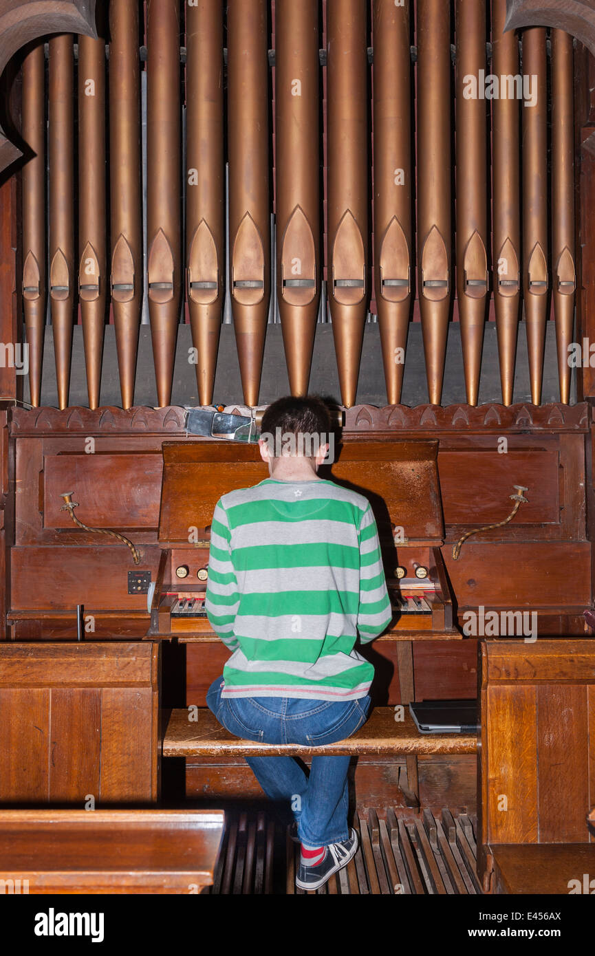 A 14 year old boy playing a pipe organ inside a UK church Stock Photo ...
