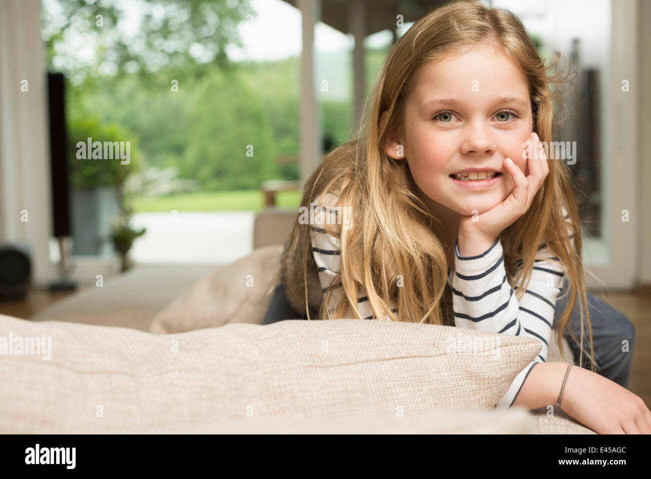 Girl half lying down on sofa Stock Photo - Alamy
