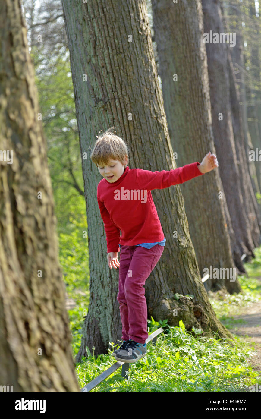 young boy balancing along a railing Stock Photo - Alamy