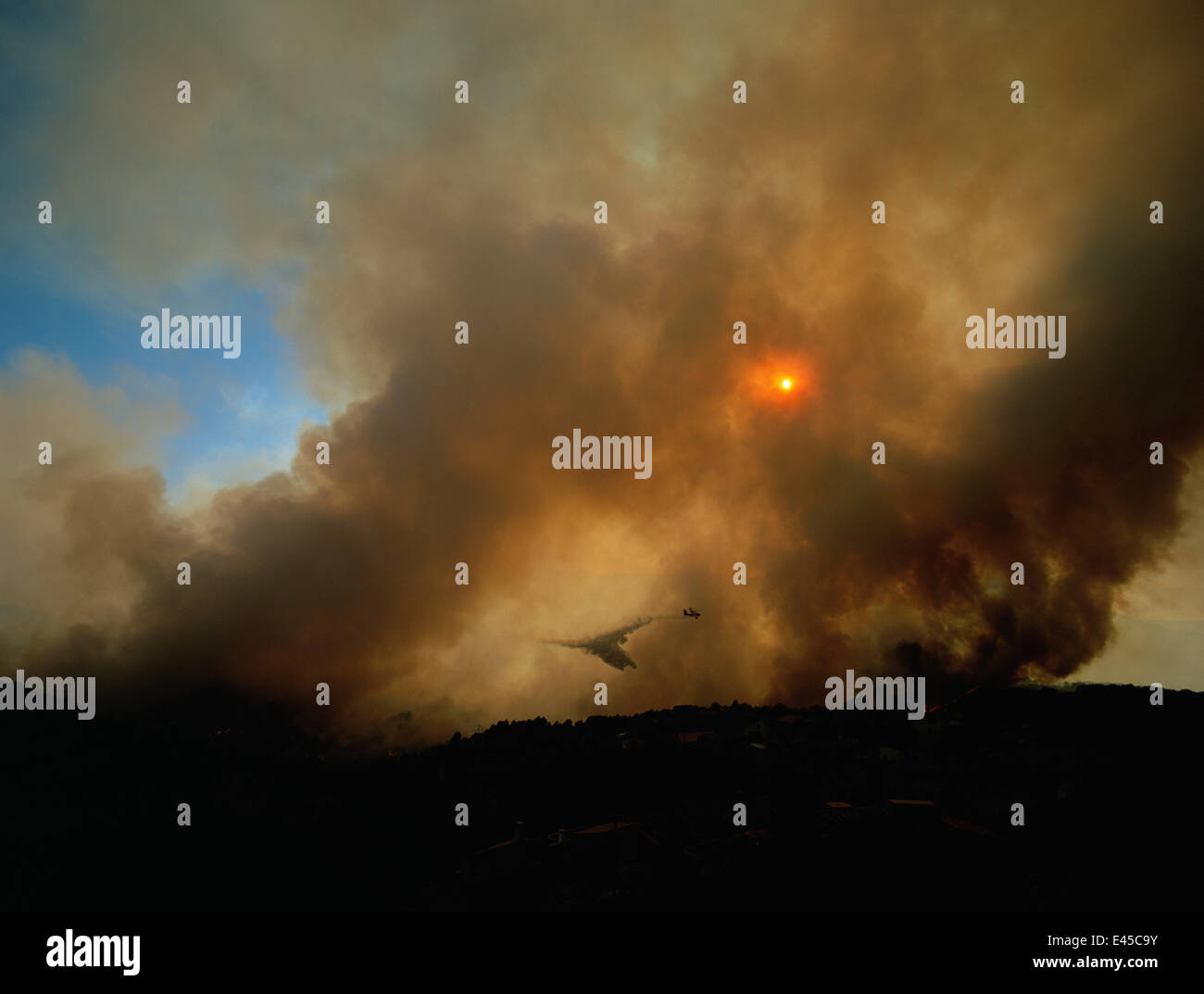 Dense smoke surrounds aeroplane dropping water / fire retardant on ...
