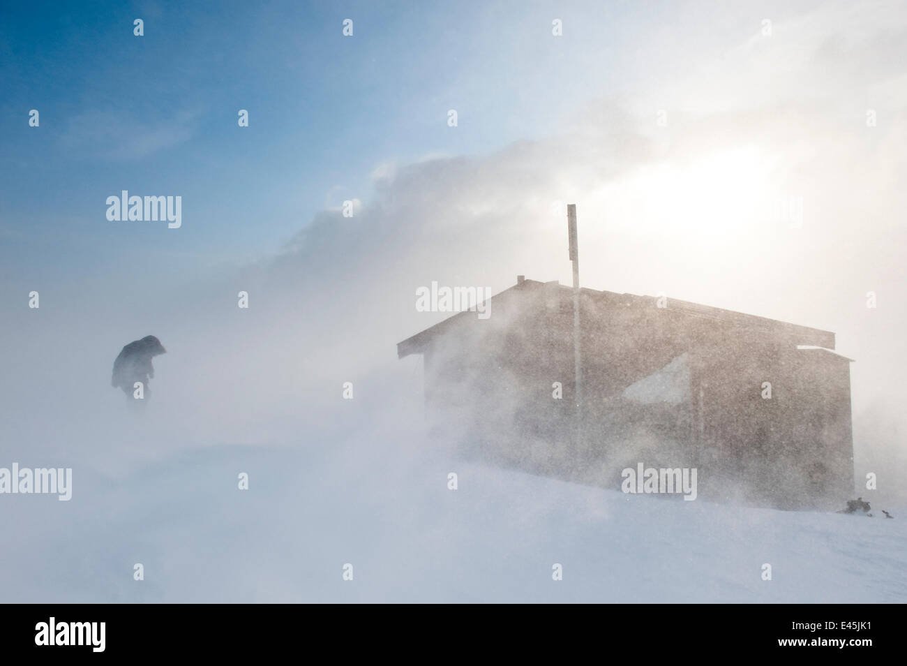 Man outside cabin in snowstorm, Agardh Bay, East coast of Spitsbergen ...