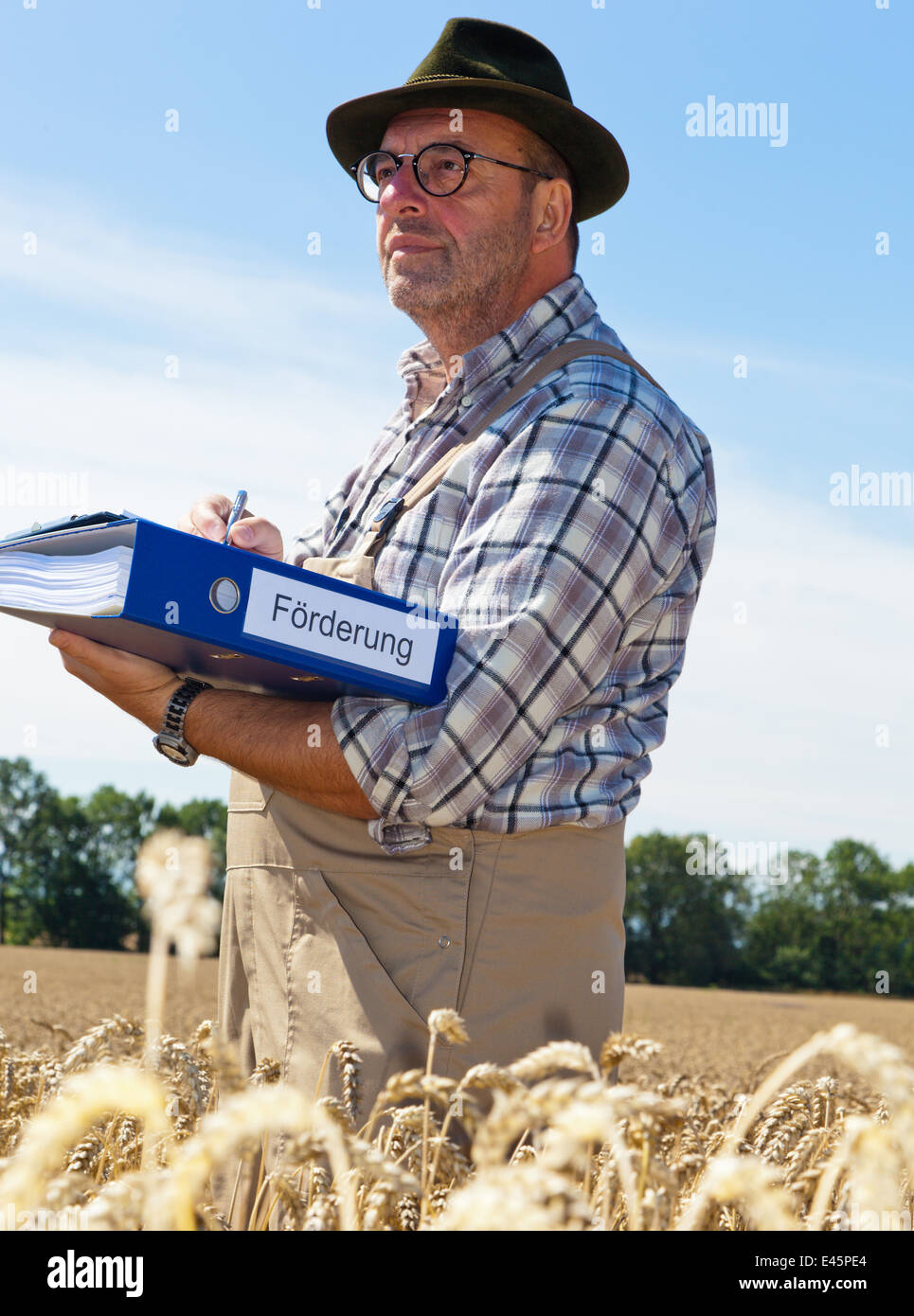 A farmer with support folder on crop field, subsidies in agriculture ...