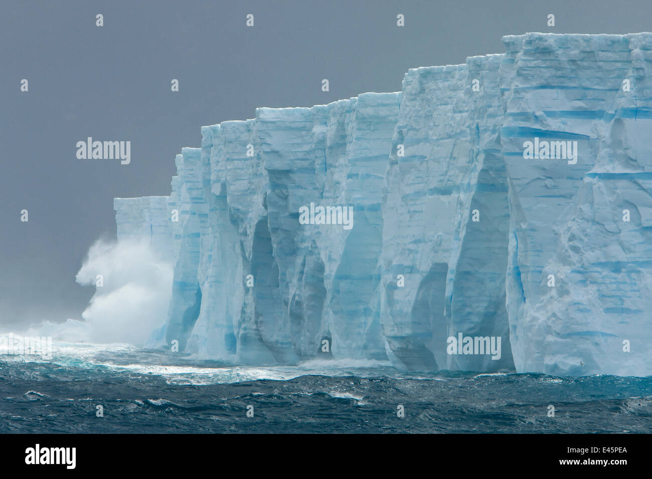 Waves crashing against ice cliffs of iceberg off the southern tip of ...