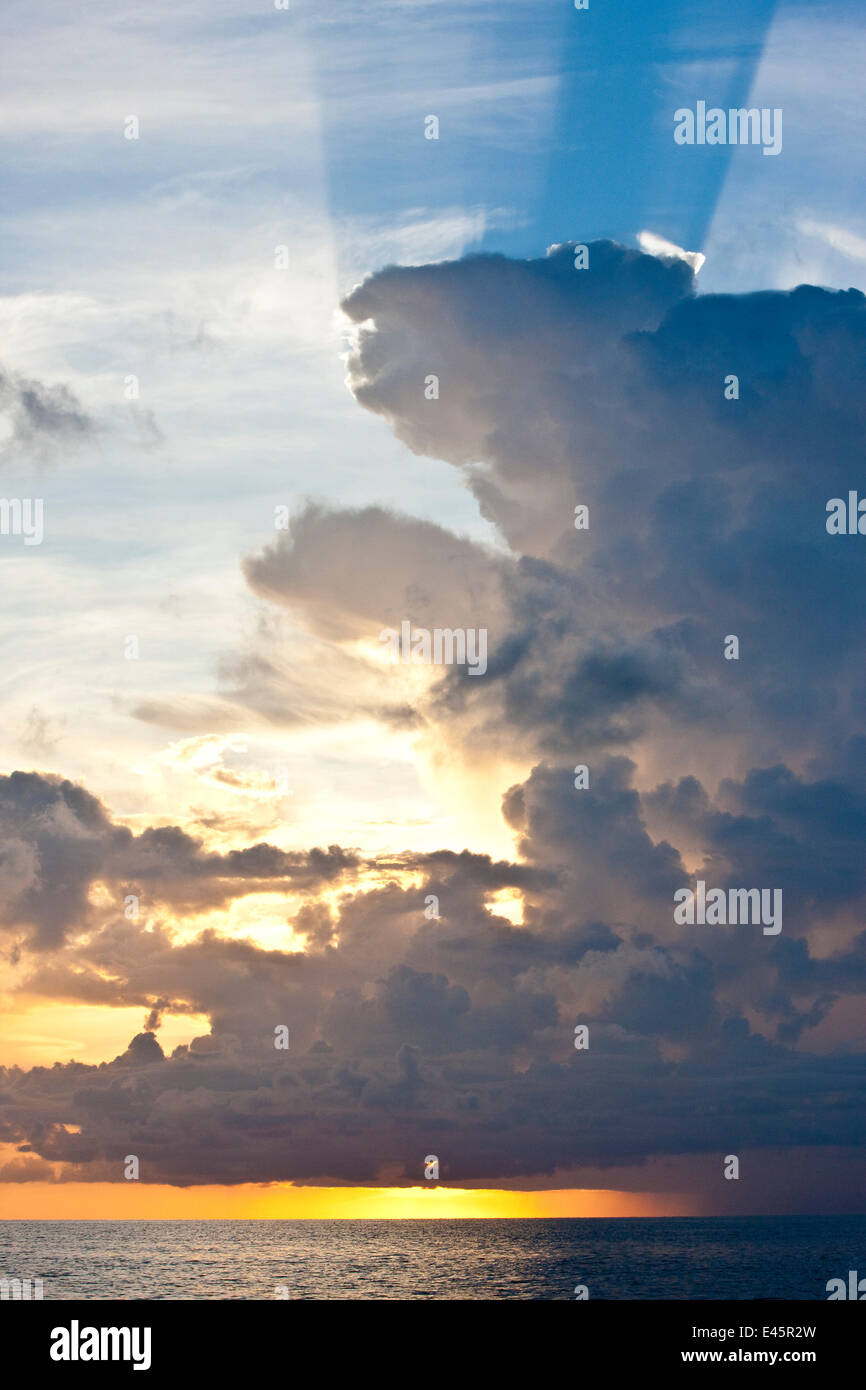 Crepuscular rays from behind a cloud at sunset in the Exumas, Bahamas ...