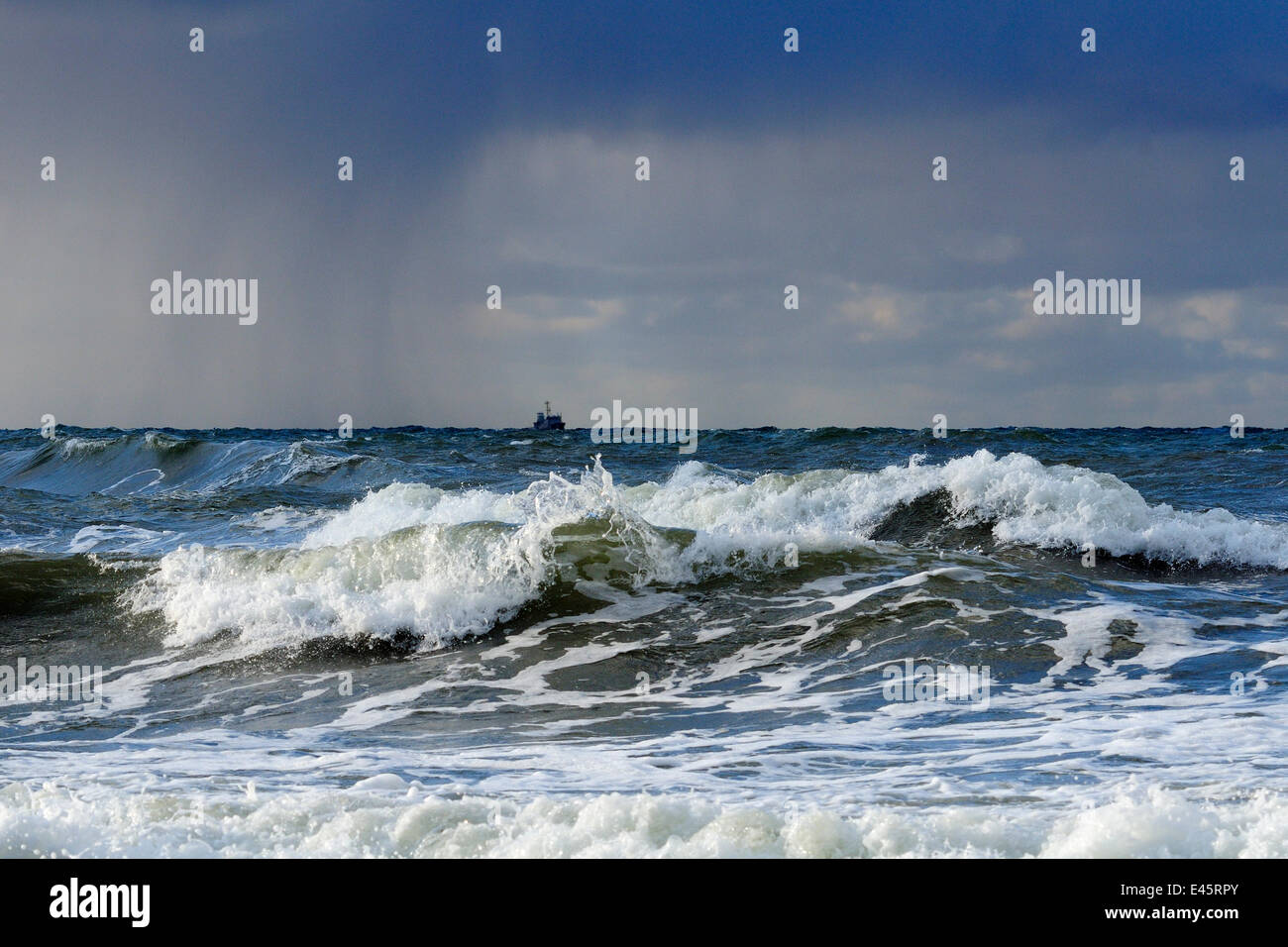 Waves breaking on stormy Baltic sea coast as curtains of rain fall ...