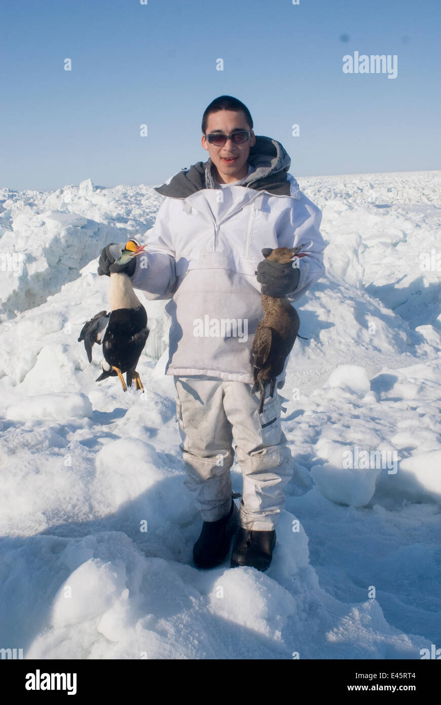 Portrait of Inupiaq / Inuit man standing with his subsistence catch of ...