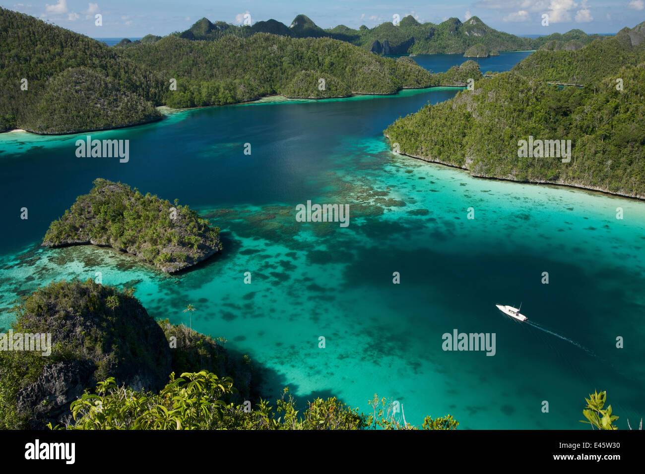 Aerial view of a boat making its way through the Wayag Islands, an ...