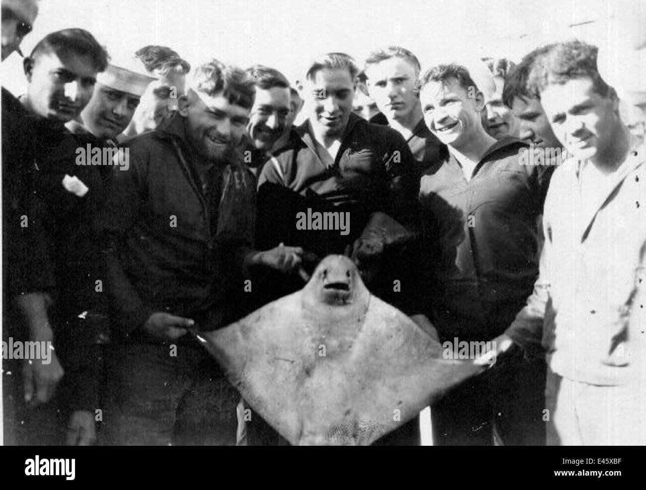 A photograph showing sailors aboard a battleship (BB 44) encountering a ...