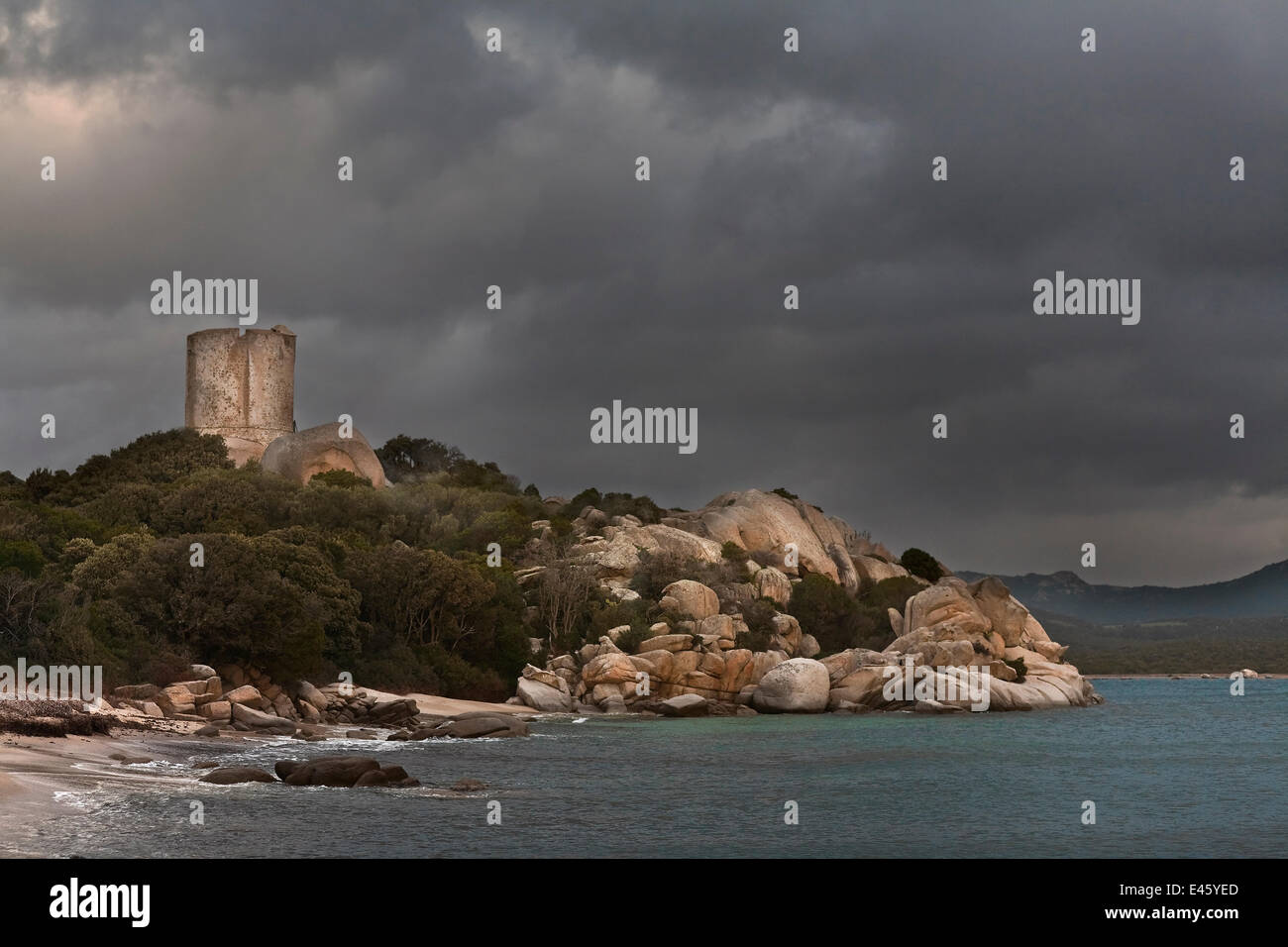 Figari bay and medieval watchtower, with dark storm clouds, Southern ...