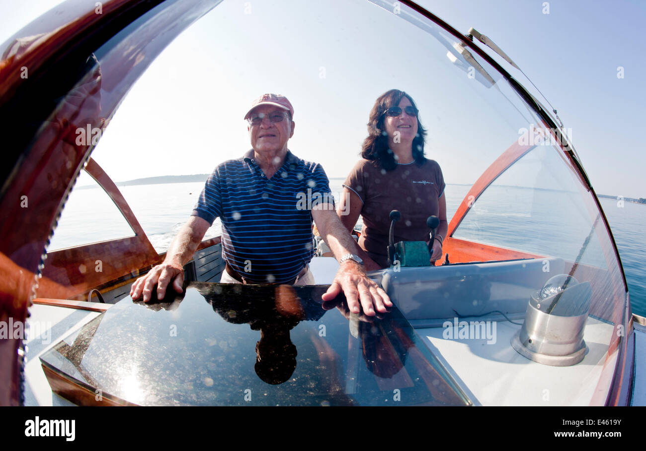 Couple in the cockpit of classic wooden power boat, Northeast Harbor ...