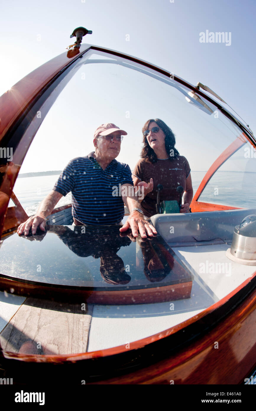 Couple in the cockpit of classic wooden power boat, Northeast Harbor ...