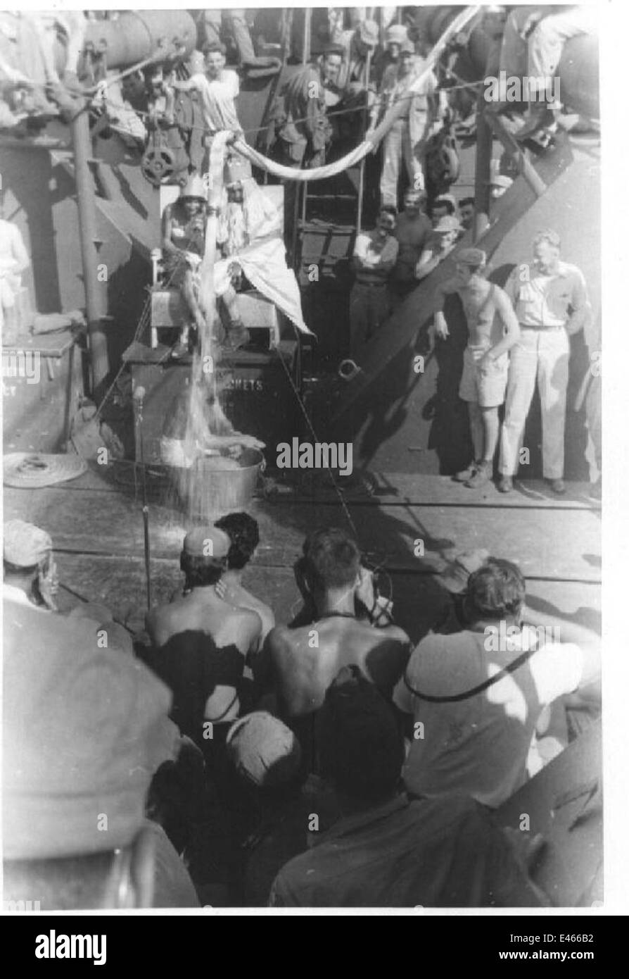 This image depicts a crossing the equator ceremony aboard a troop ...