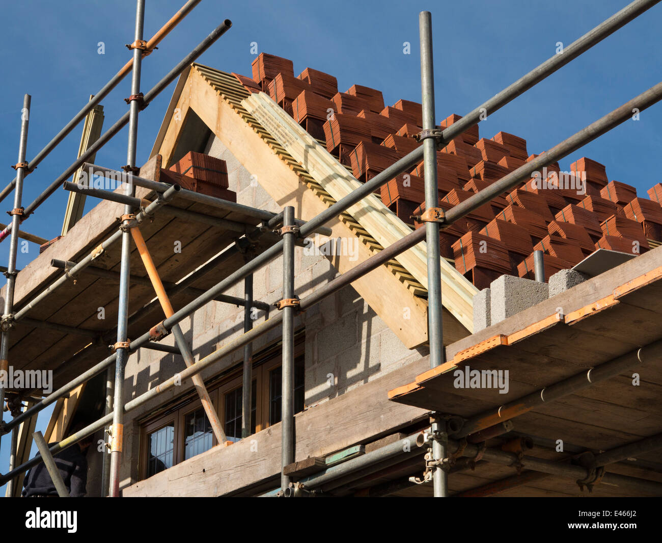 self building house, constructing roof, clay tiles stacked in bundles ...