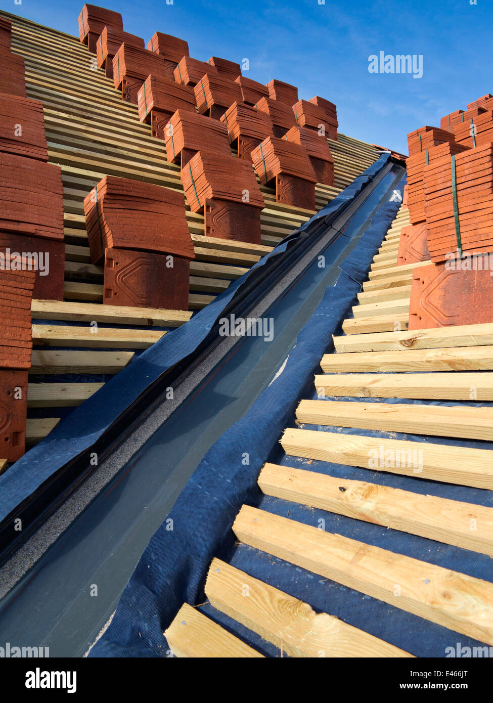 self building house, constructing roof, clay tiles stacked in bundles ...