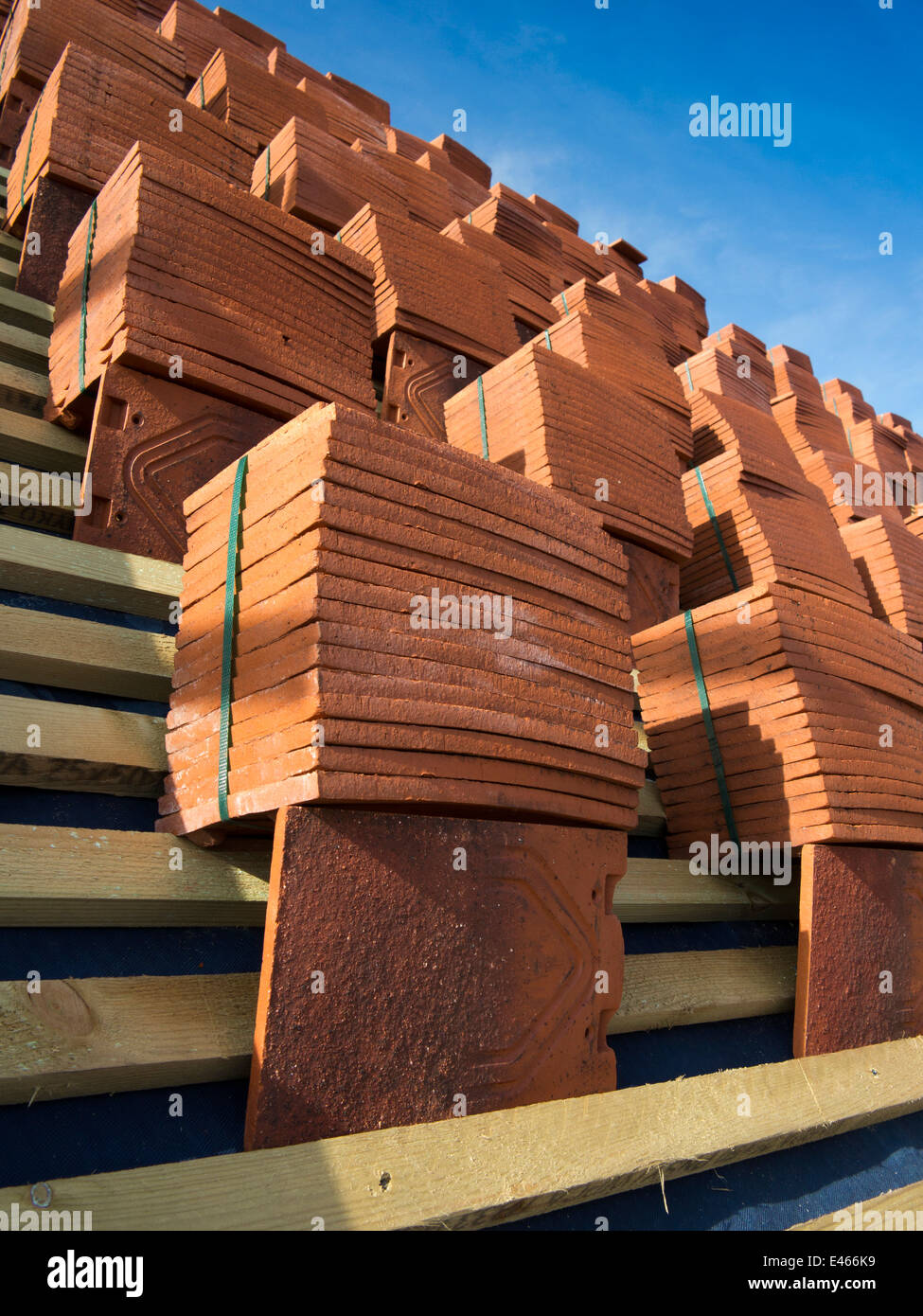 self building house, constructing roof, clay tiles stacked in bundles ...