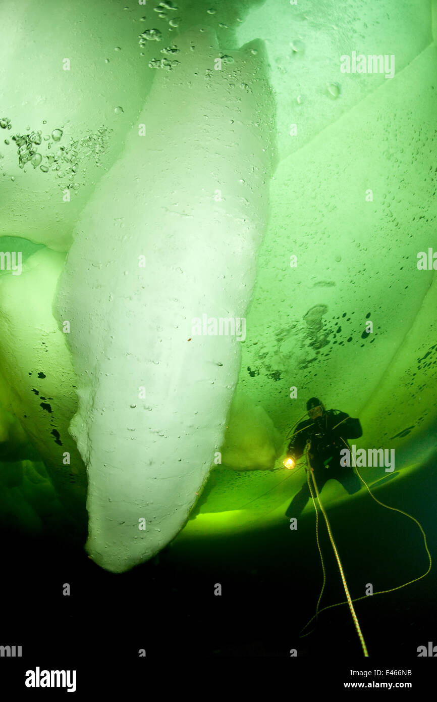 Scuba diver under ice next to large ice formation, Arctic circle Dive ...