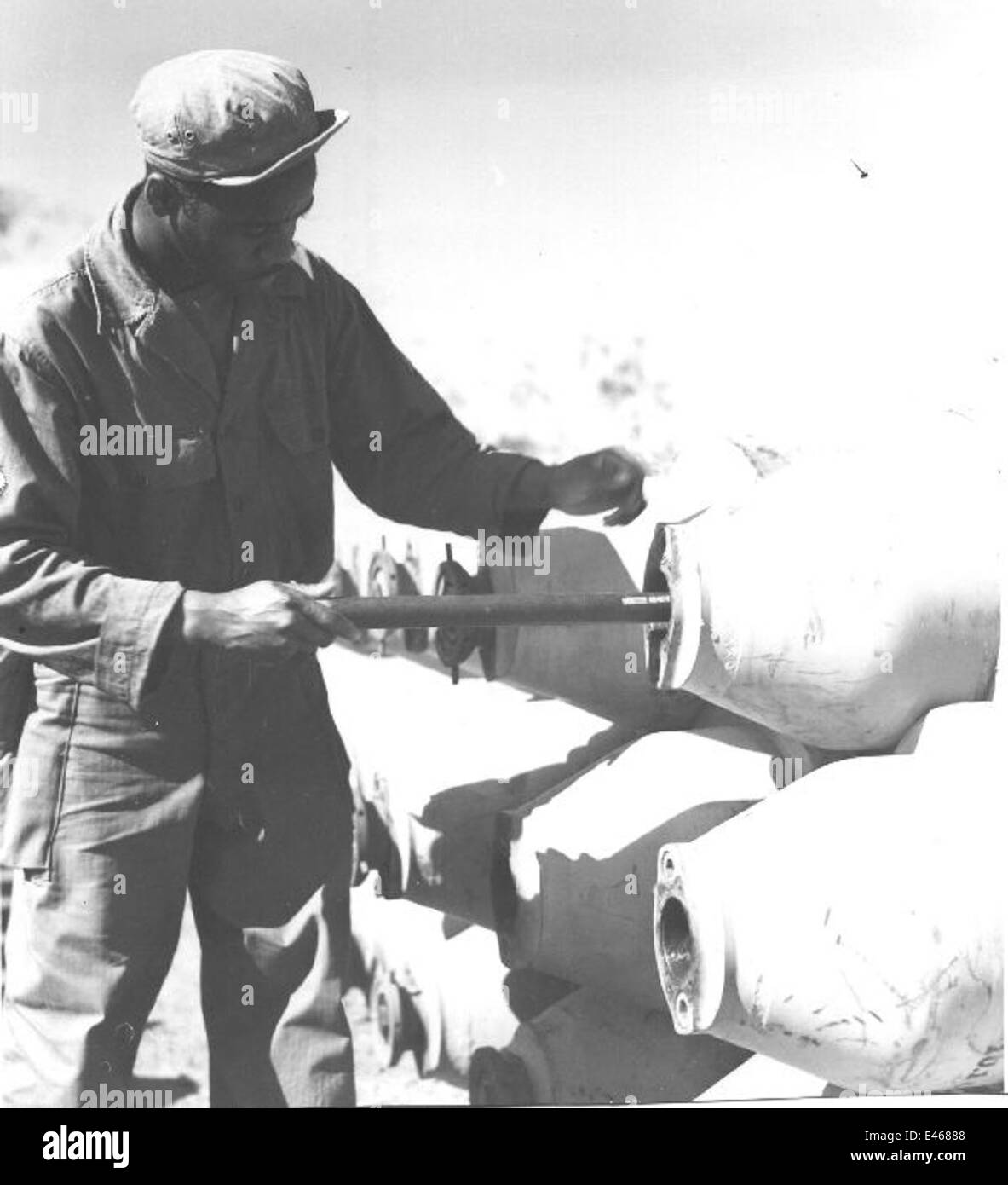 This historical image shows the loading of incendiary bombs, likely in ...