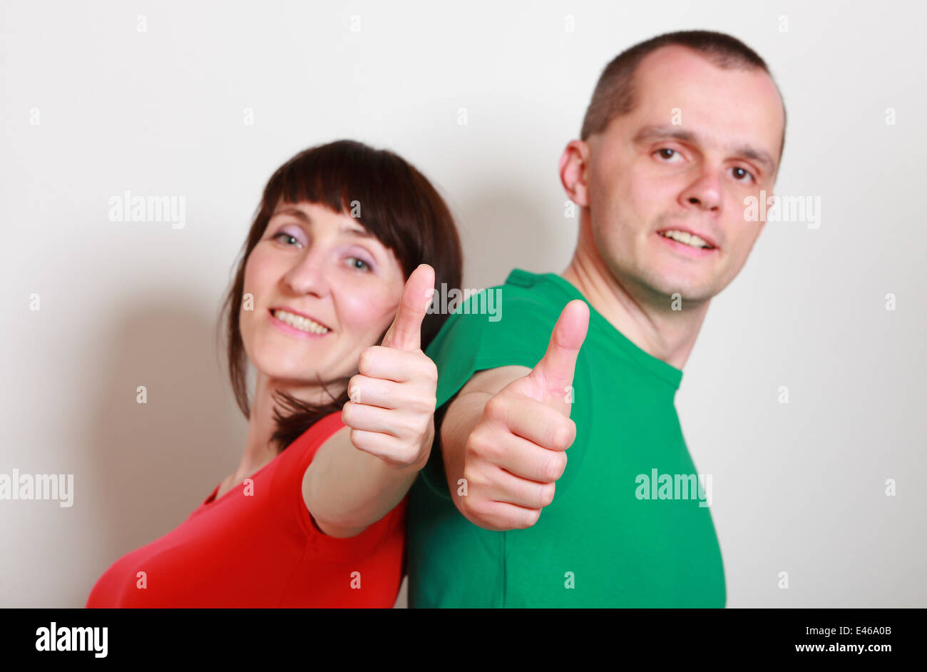 Smiling woman and man showing thumbs up, showing positive emotions ...
