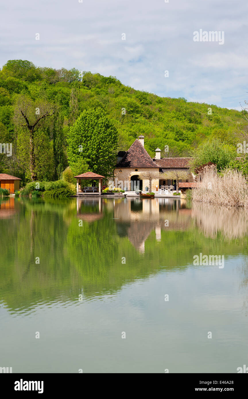 Exterior facade of a 17th century french mill seen from across a small ...