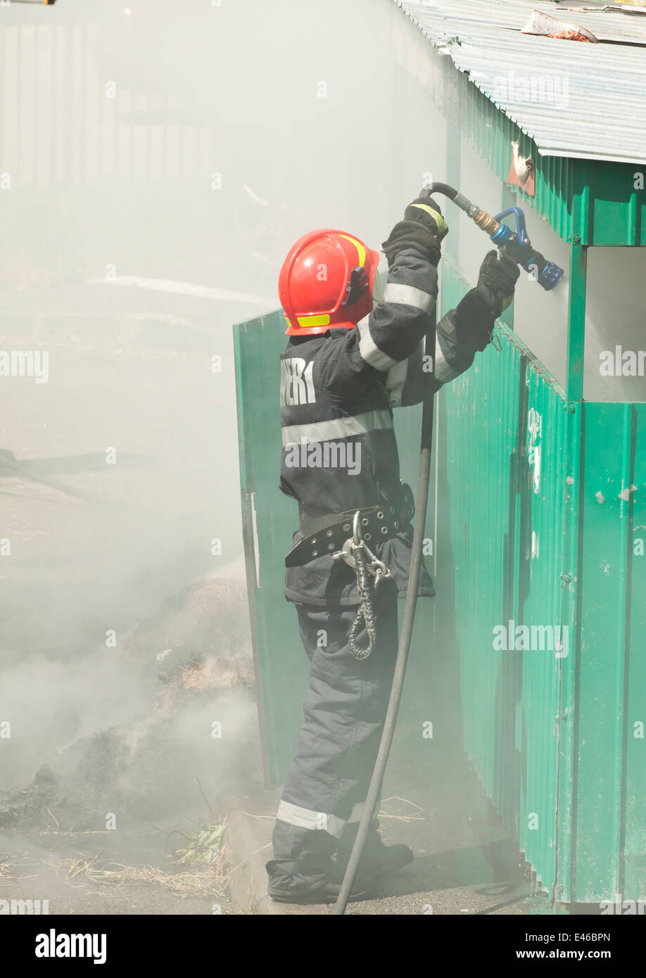 Firefighter in action - Fireman extinguishing a fire Stock Photo - Alamy