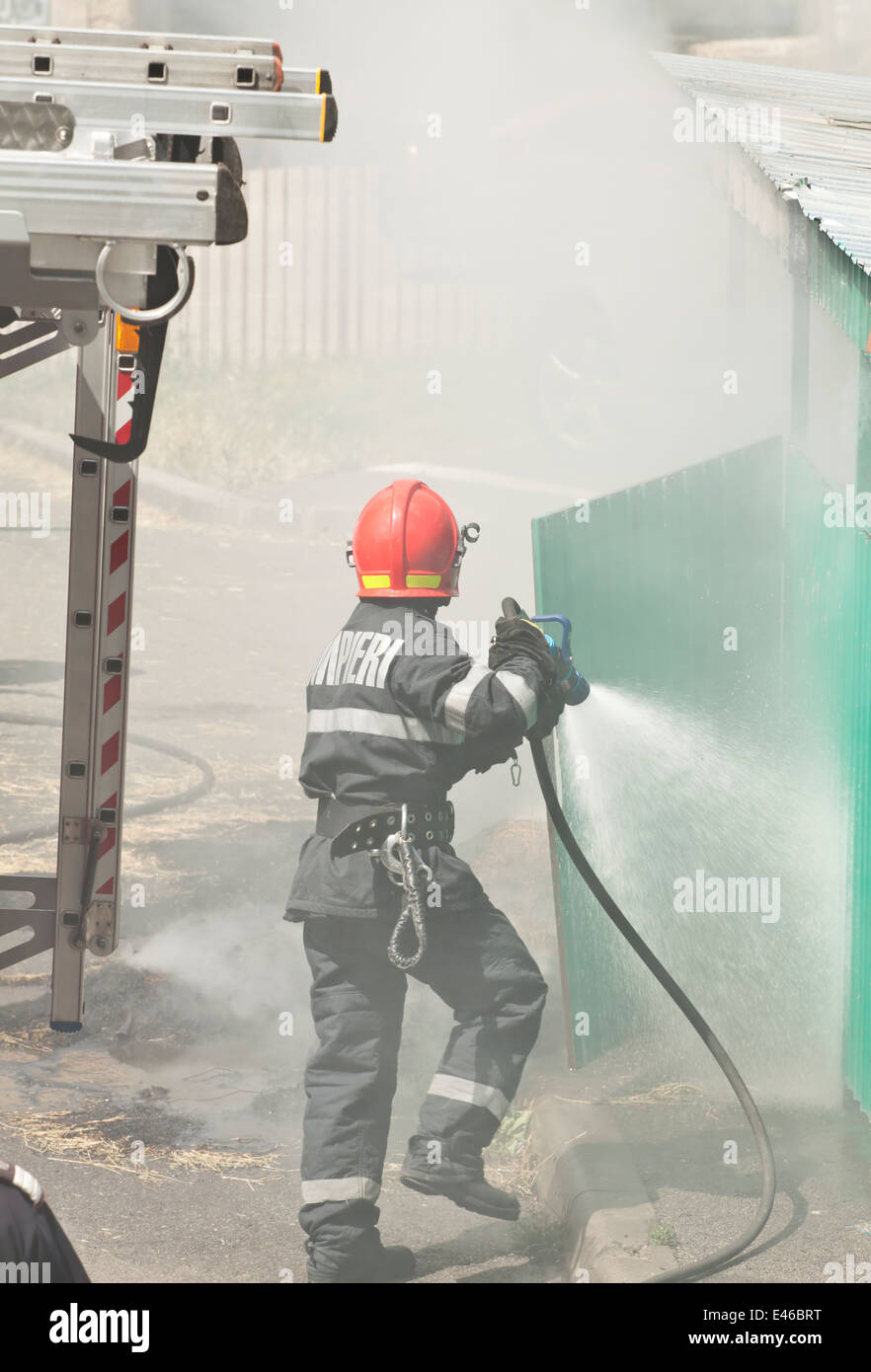 Firefighter in action - Fireman extinguishing a fire Stock Photo - Alamy