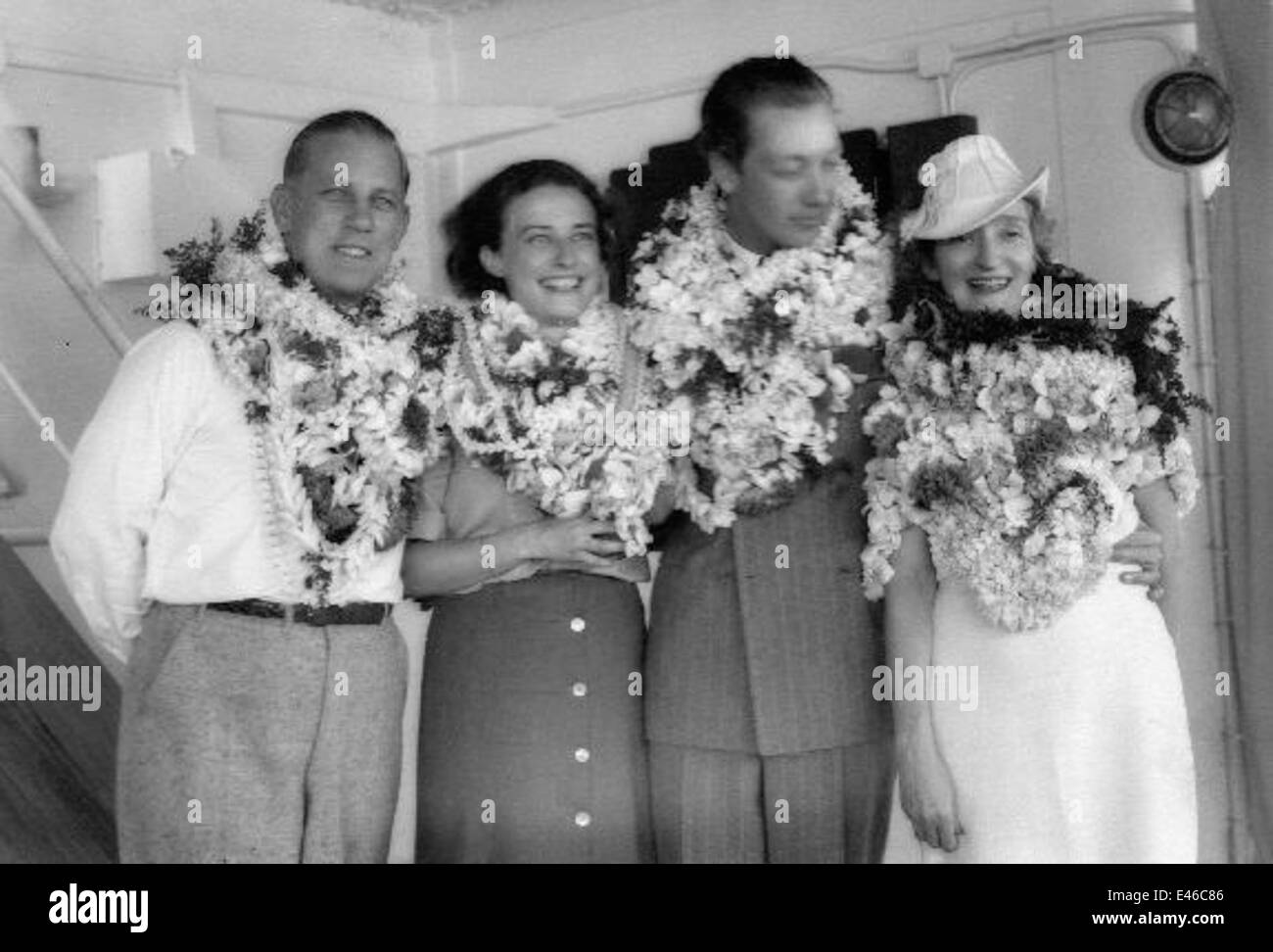 This image shows a group of individuals standing with smiles, wearing ...