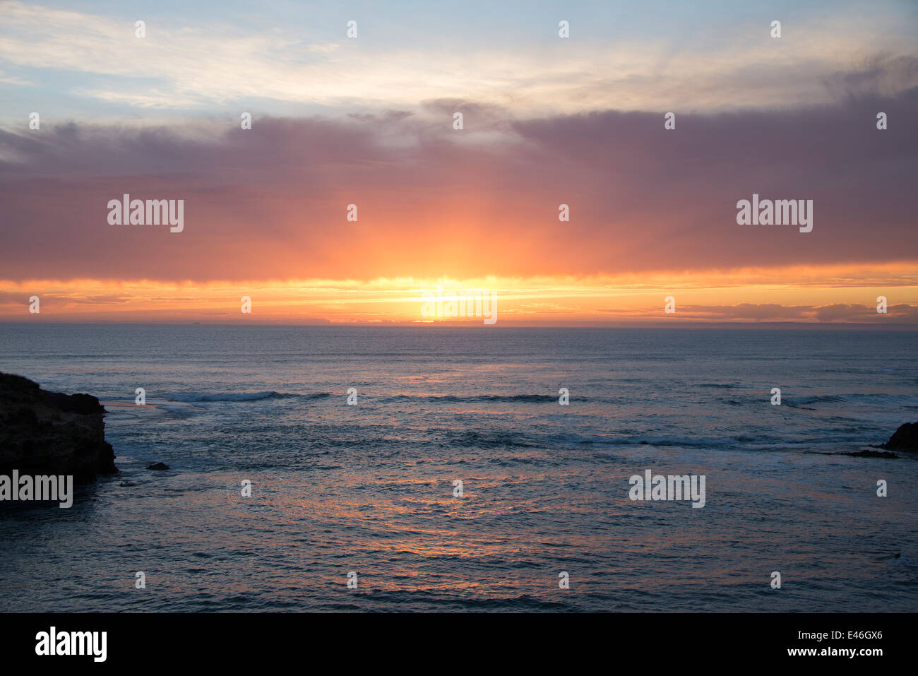 sunset on the ocean horizon at dusk showing the brillant sun rays over ...