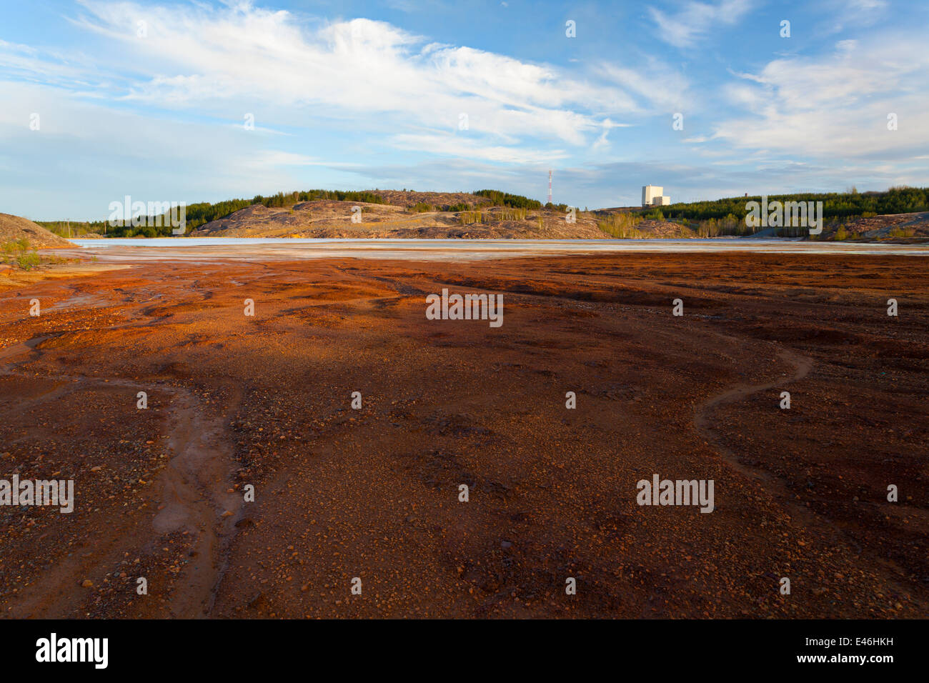 Rock and soil turn intense rusty and red colours as a tailings pond ...