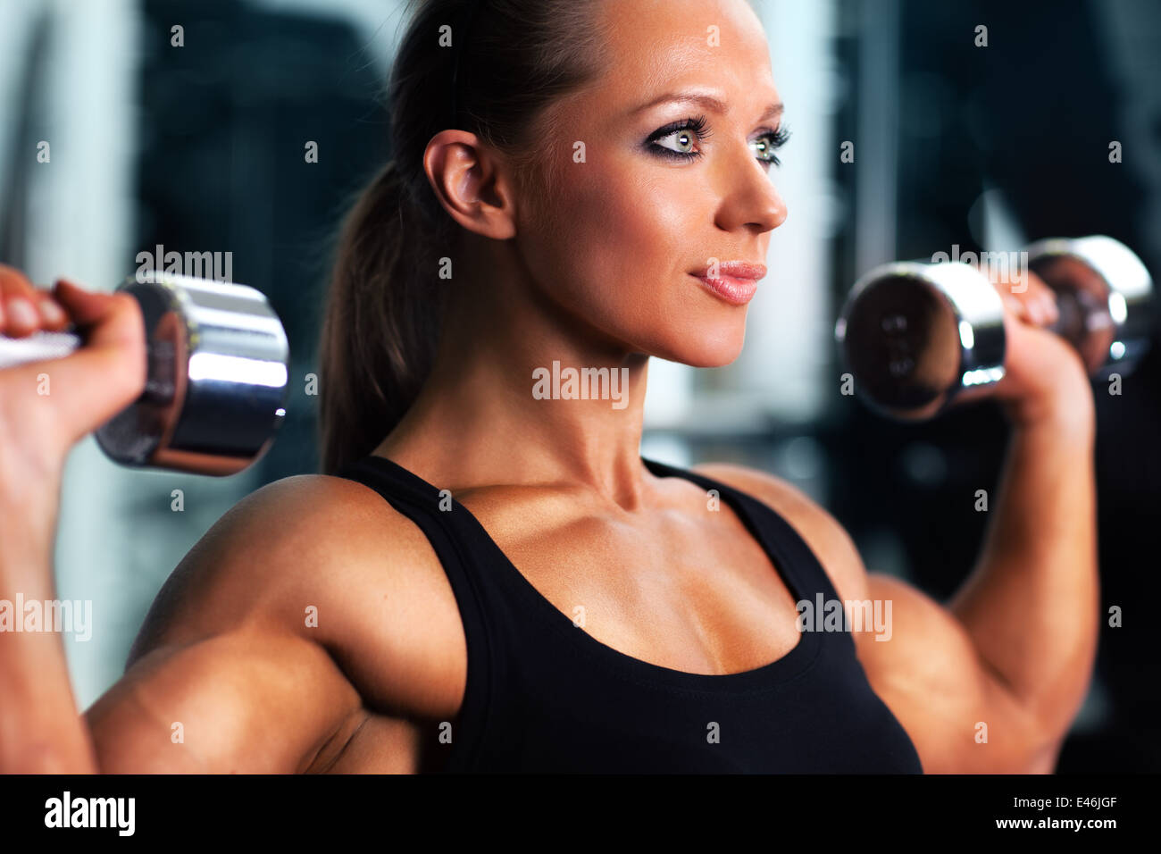 Young woman bodybuilder with dumbbell Stock Photo - Alamy
