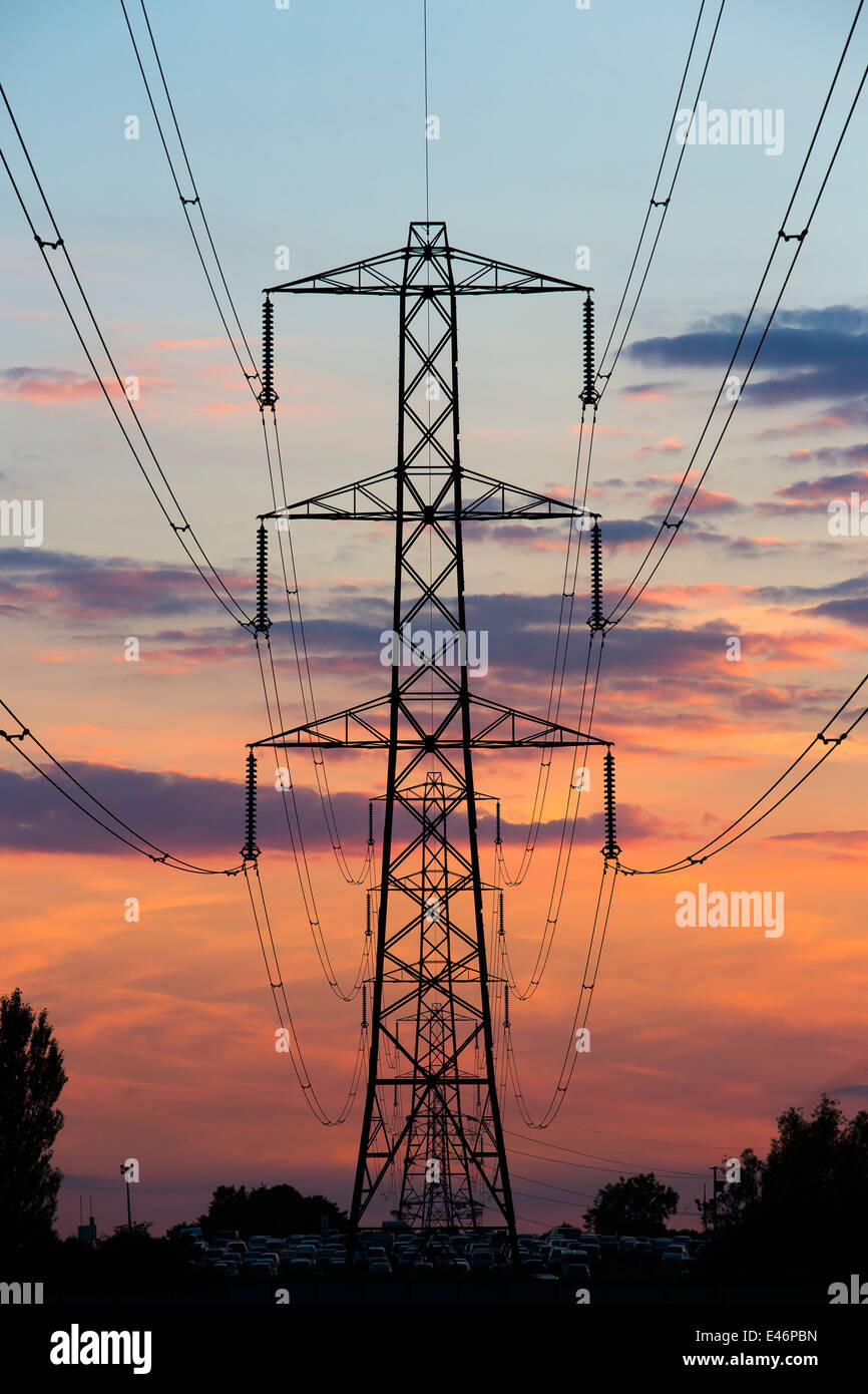 Electricity pylons at sunset silhouetted against a beautiful evening ...