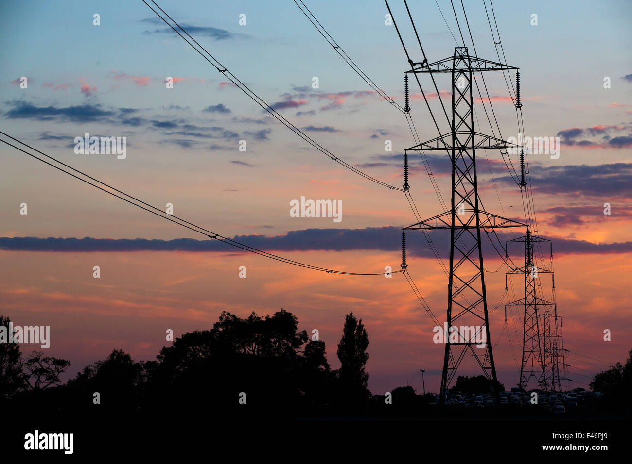Electricity pylons at sunset silhouetted against a beautiful evening ...