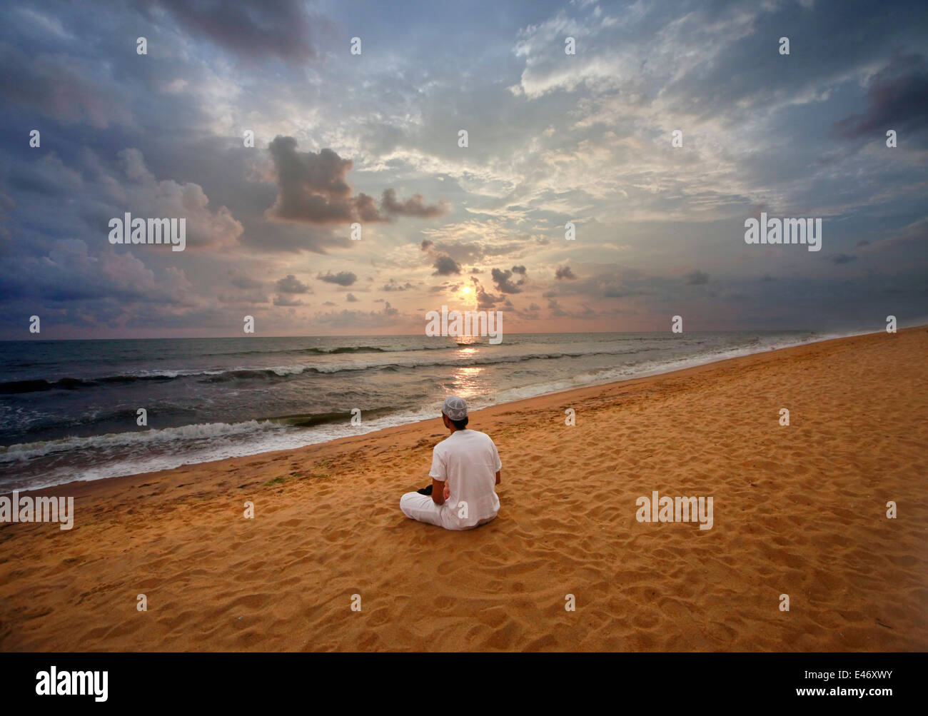 Guy meditating at sunset sitting on coastline. Sri Lanka Stock Photo ...