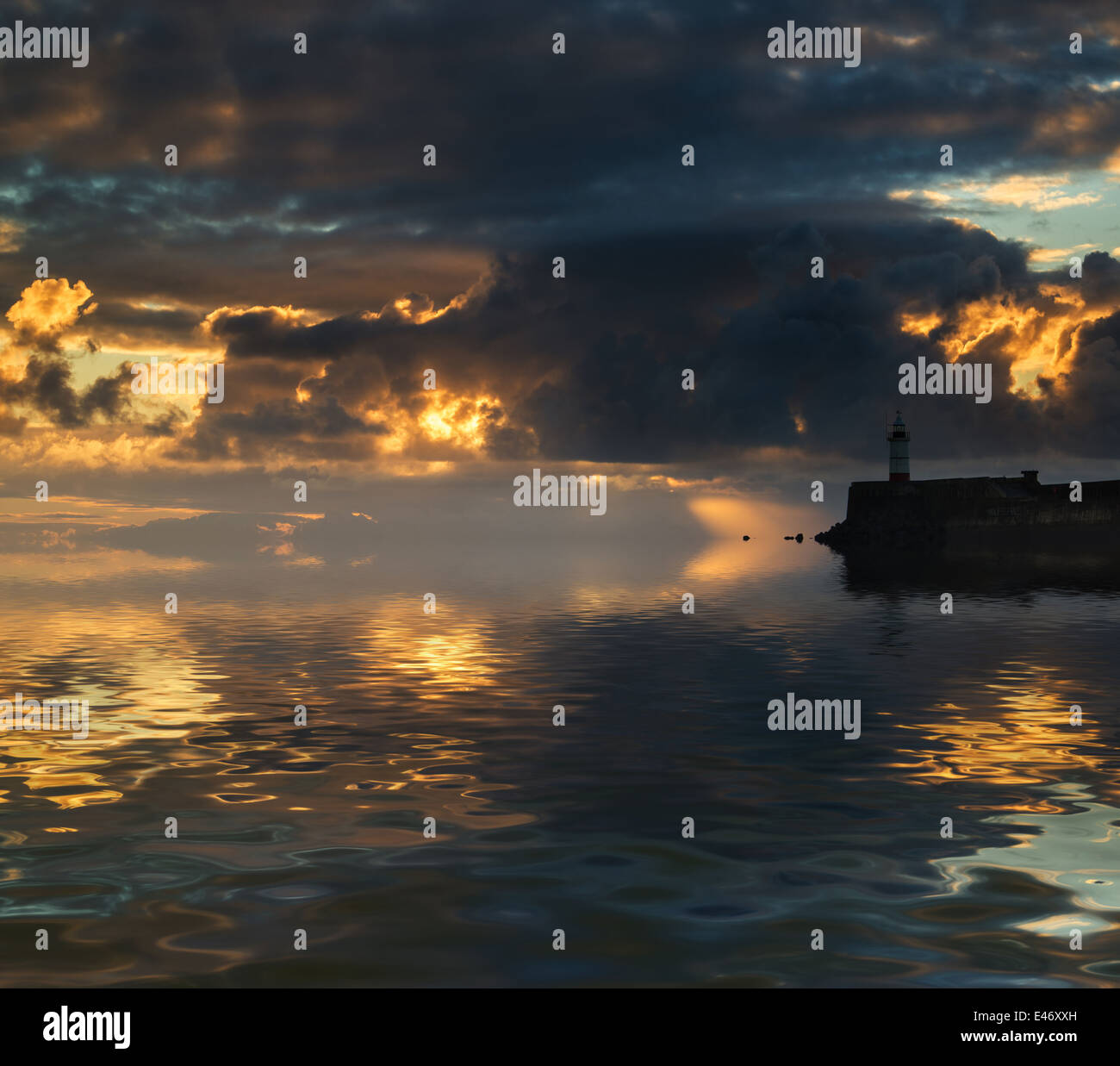 Stunning sunrise over ocean with lighthouse and harbor wall Stock Photo ...