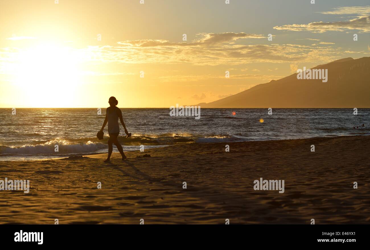 A walker goes along a beach during sunset in Kihei (Maui Stock Photo ...