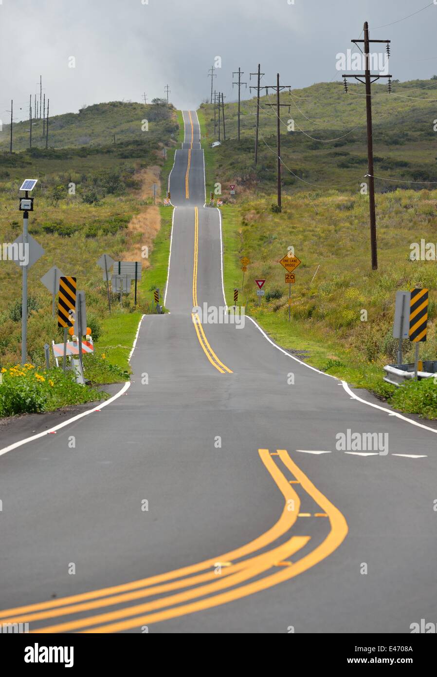 A side road of the highway 200 goes up a hill near the Mauna Kea ...
