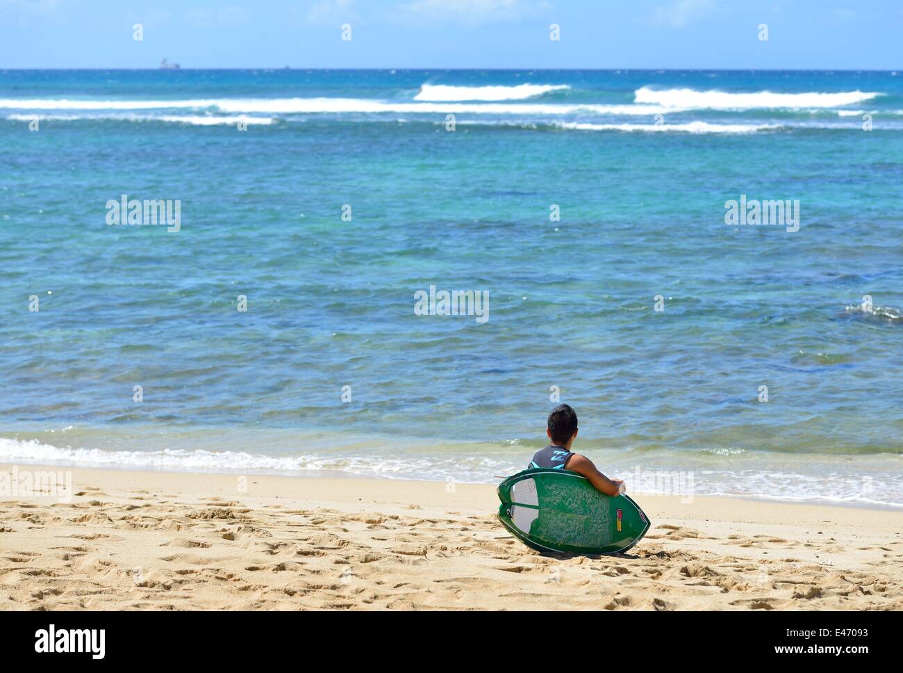 A surfer sits at the Kuilei Cliffs Beach Park near Honolulu (Oahu Stock ...