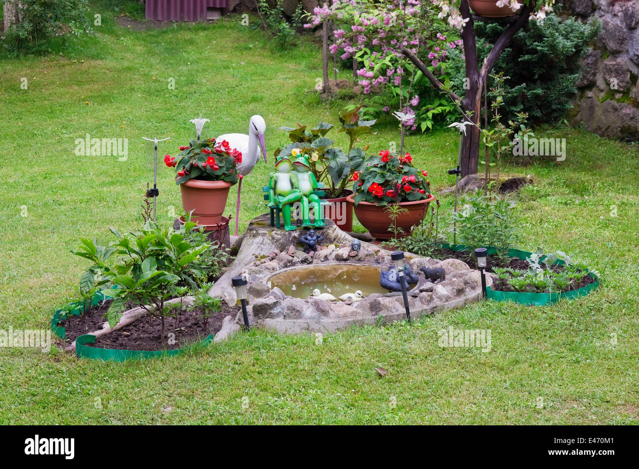 The children's Alpine hill in a garden is decorated with plastic mass ...